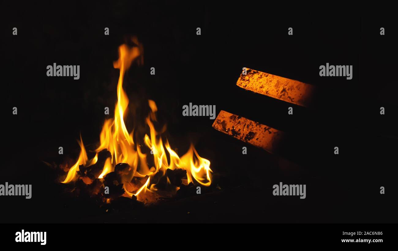 Forge fire in furnace. Blacksmith tempers a steel product in a stove ...