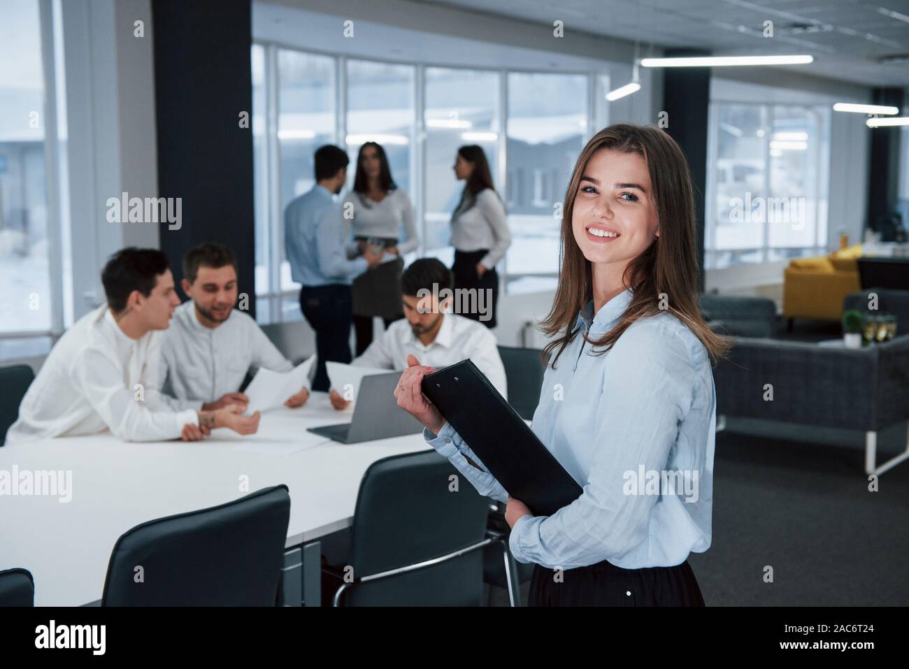 Cute european woman. Portrait of young girl stands in the office with ...