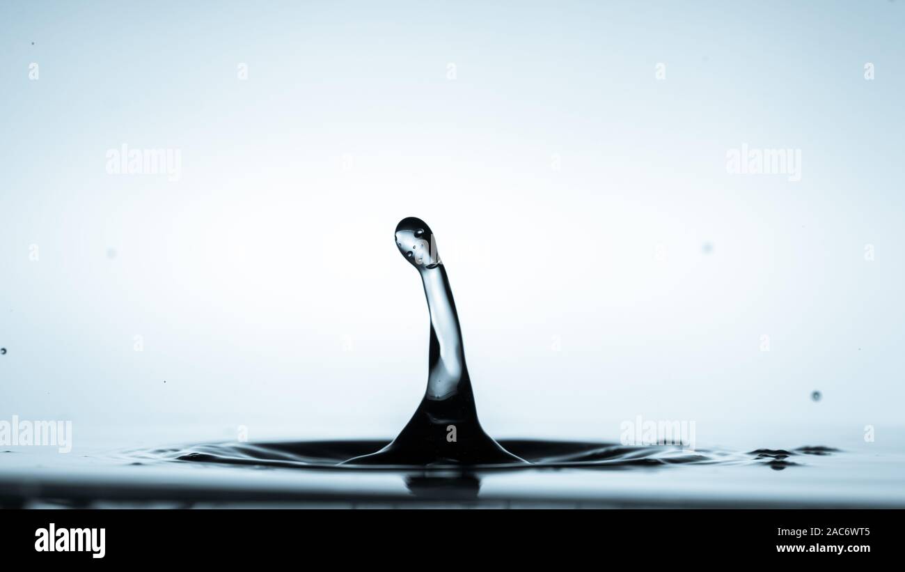 Close-up of a water drop falling on water surface Stock Photo - Alamy