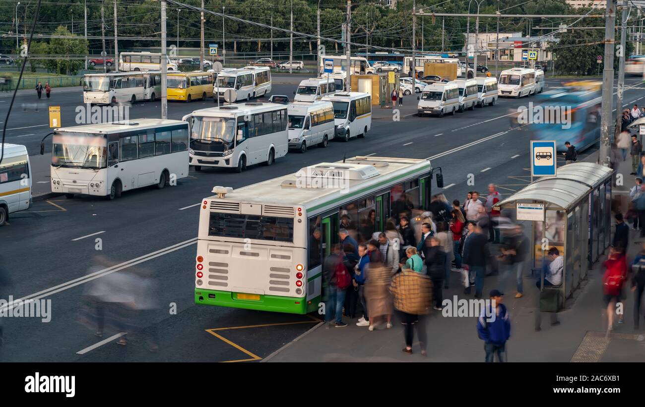 passengers in the queue for boarding the bus on a busy street at the ...