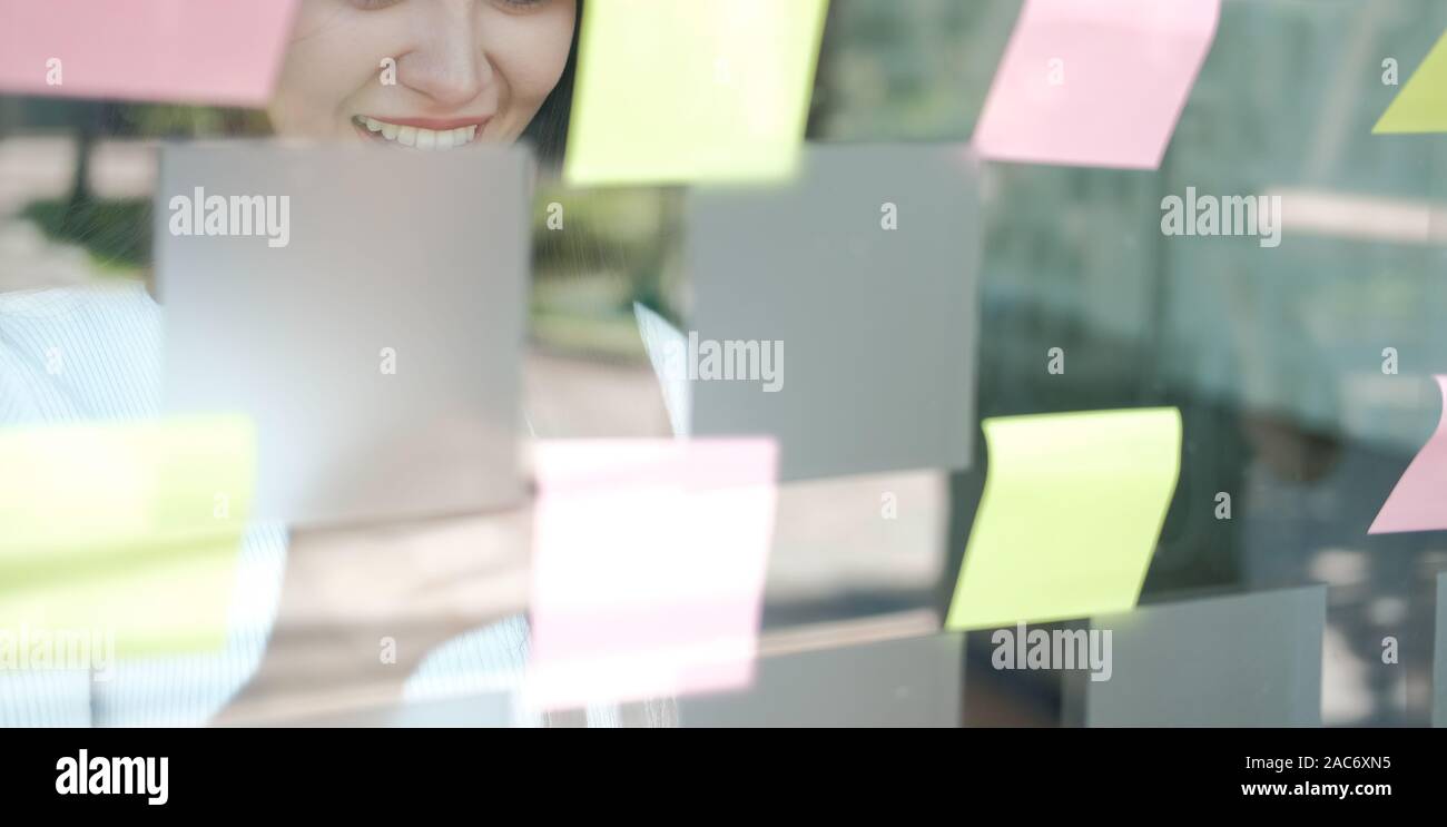 businesswoman woman thinking planning with adhesive notes on glass wall ...