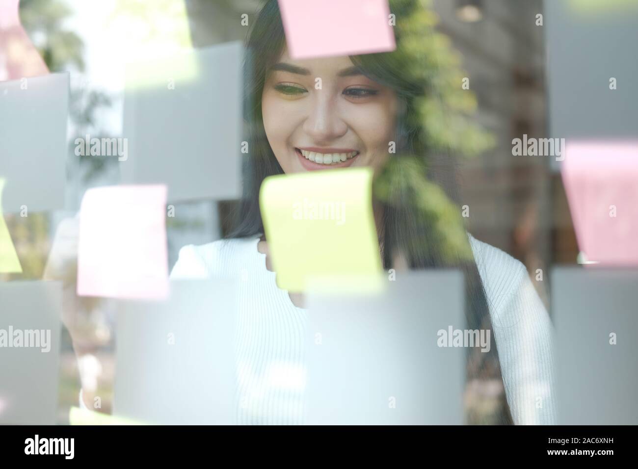businesswoman woman thinking planning with adhesive notes on glass wall ...