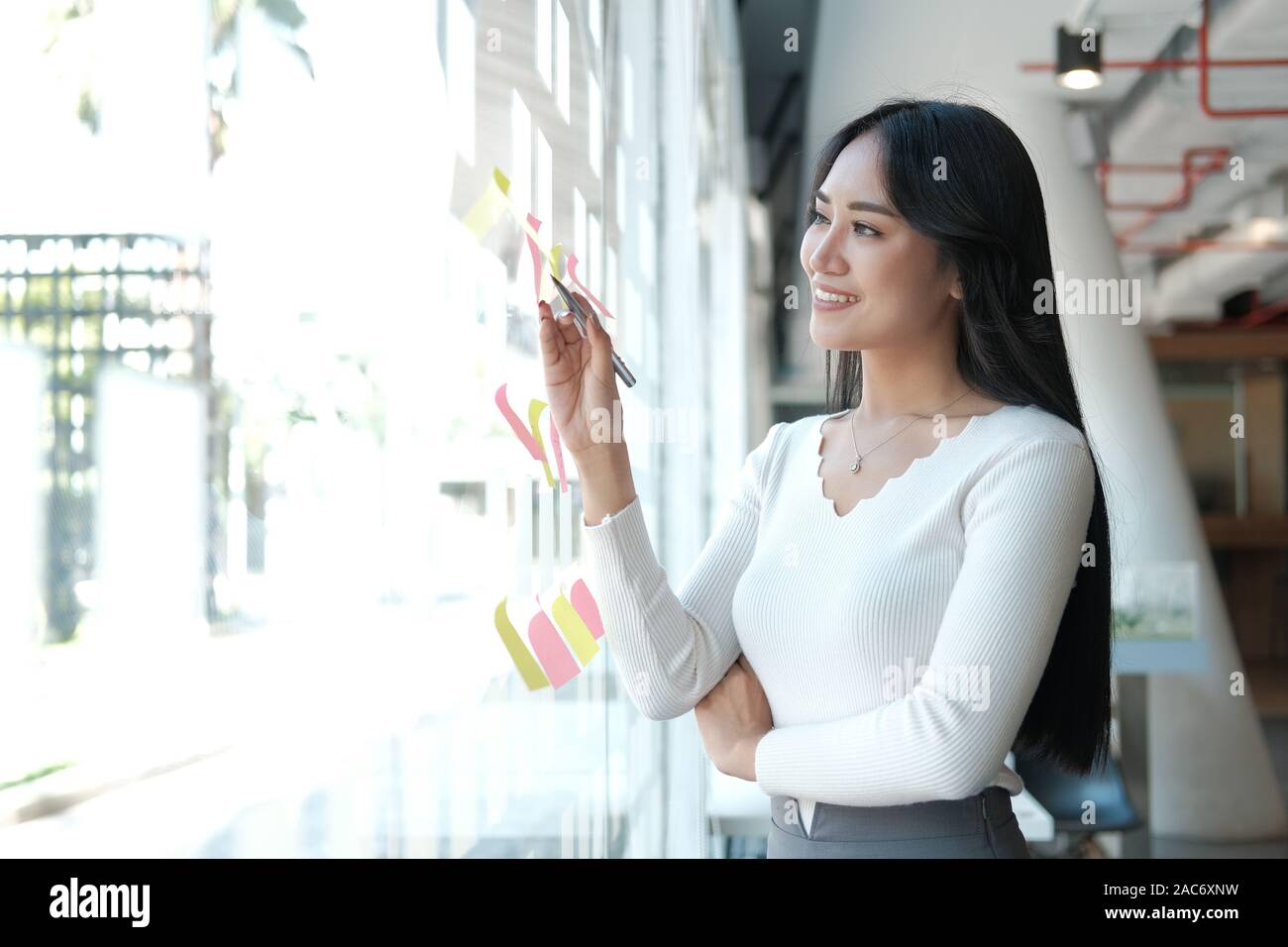 businesswoman woman thinking planning with adhesive notes on glass wall ...