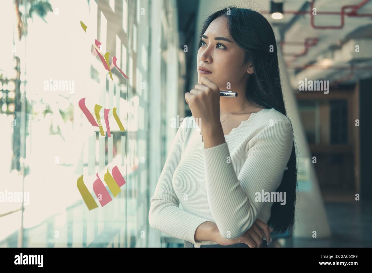 businesswoman woman thinking planning with adhesive notes on glass wall ...