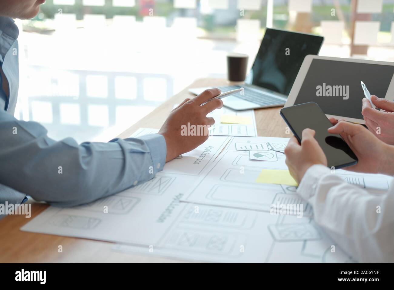user experience UX designer designing web on smart phone layout. UI planning mobile application ...