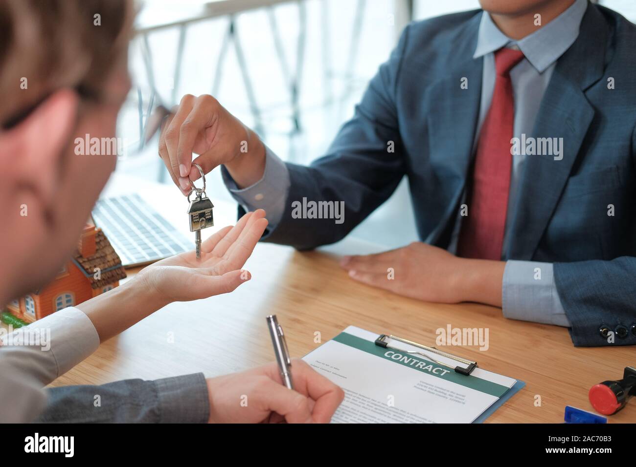realtor agent giving house key to couple customer. client signing ...