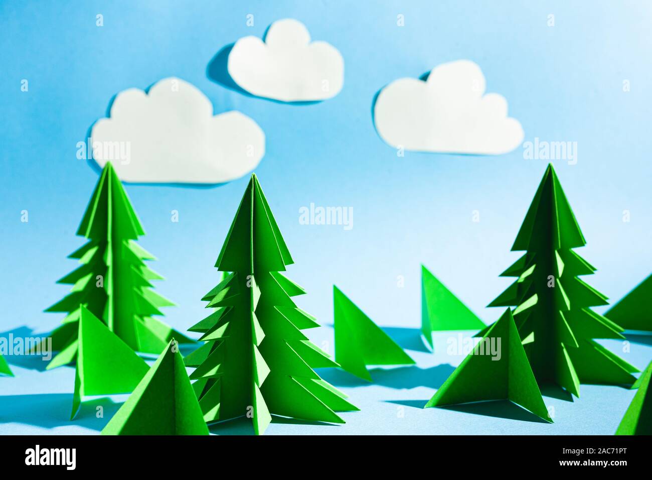 Origami forest landscape. Green Christmas trees, pines, and blue sky ...