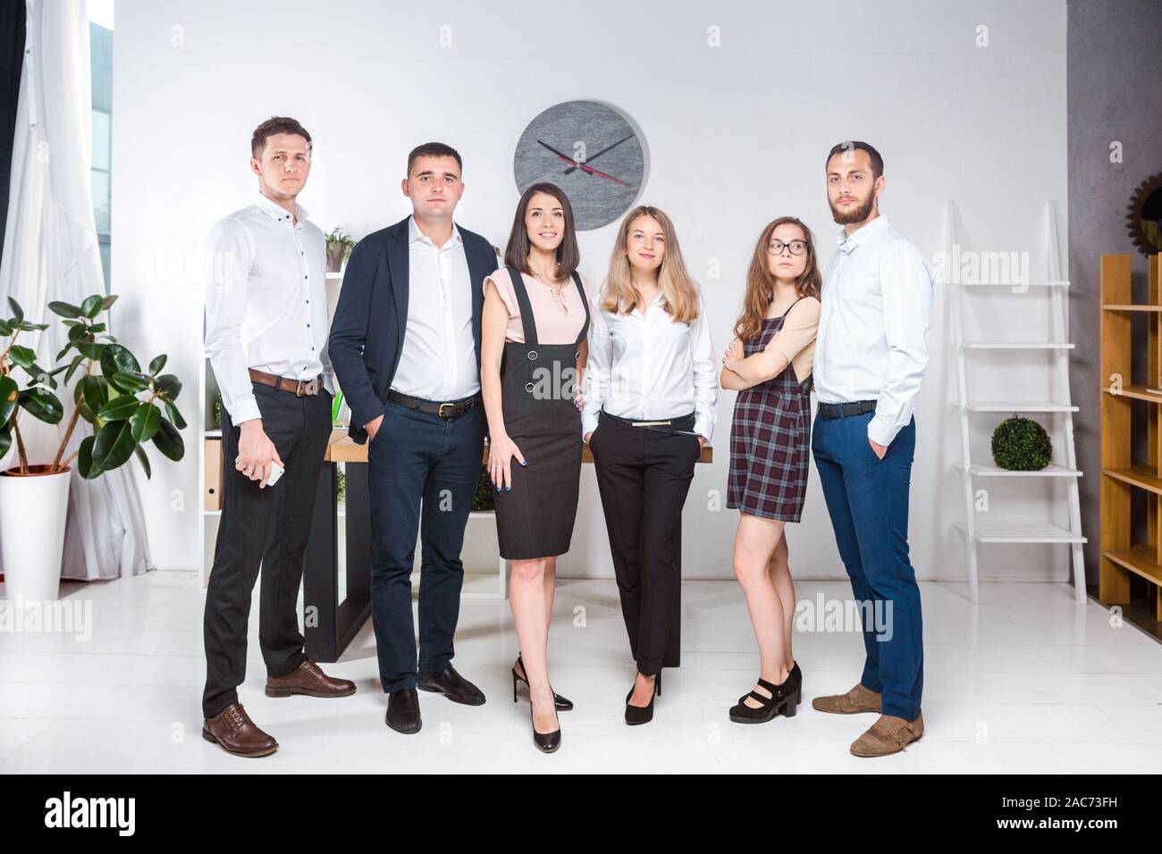 Smiling employees standing looking camera making team picture in office ...