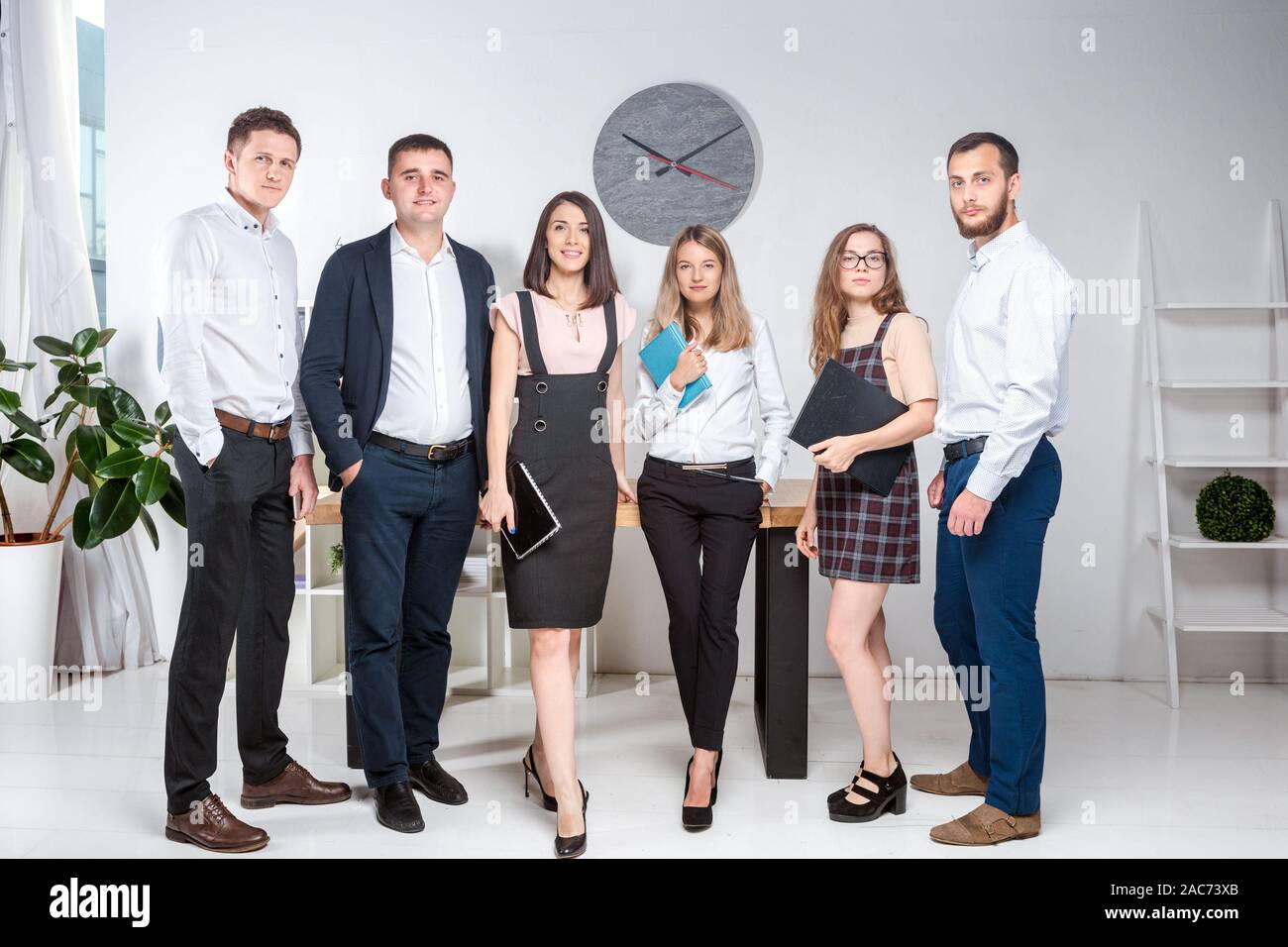 Smiling employees standing looking camera making team picture in office ...