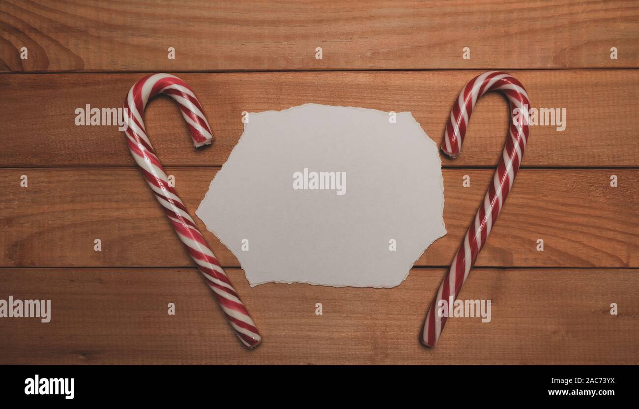 Beautiful striped hard candy cane staff on a red wooden table ...