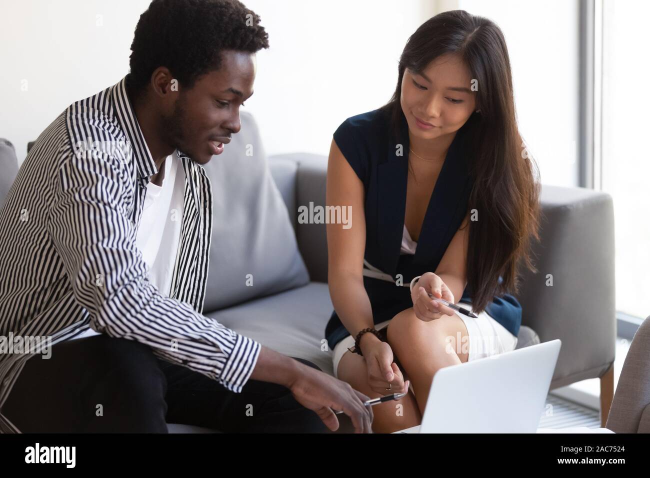Asian african colleagues using business application on computer working ...