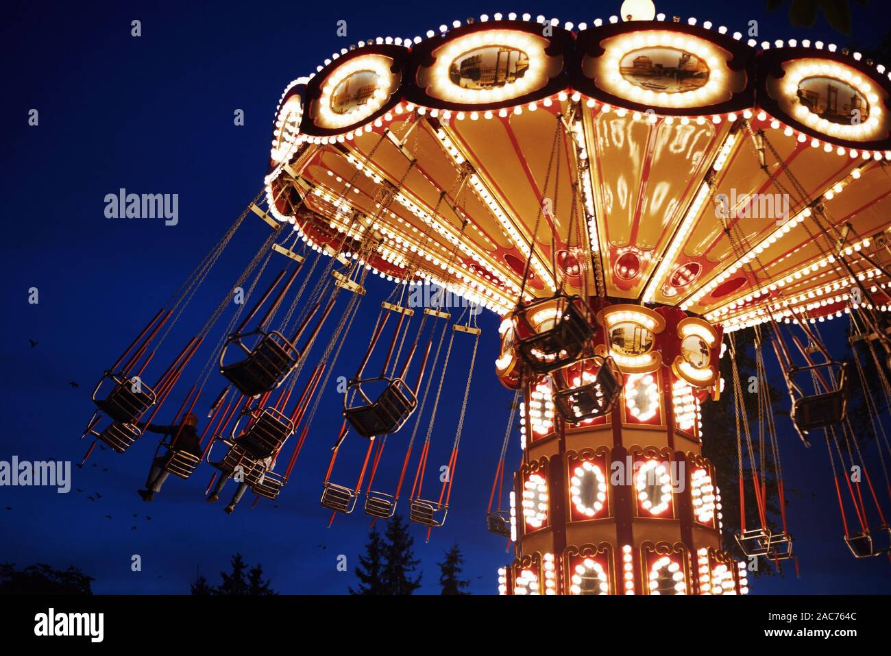 Carousel Merry-go-round in amusement park at night city Stock Photo - Alamy