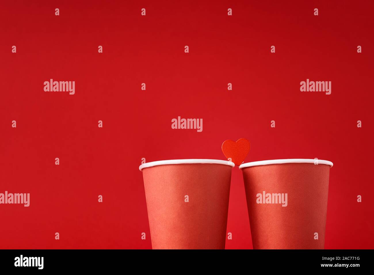 Two red coffee cups with heart as couple in love on red background ...