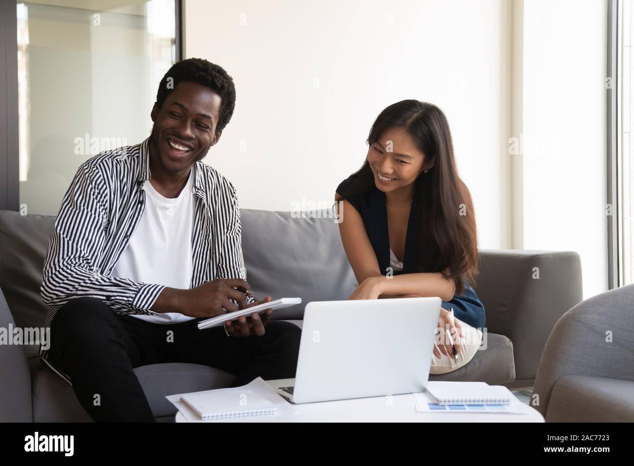 Cheerful multiracial colleagues preparing common task using pc Stock ...