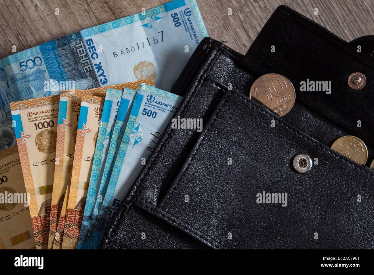 Tenge on wooden background with coins. Tenge is the national currency ...