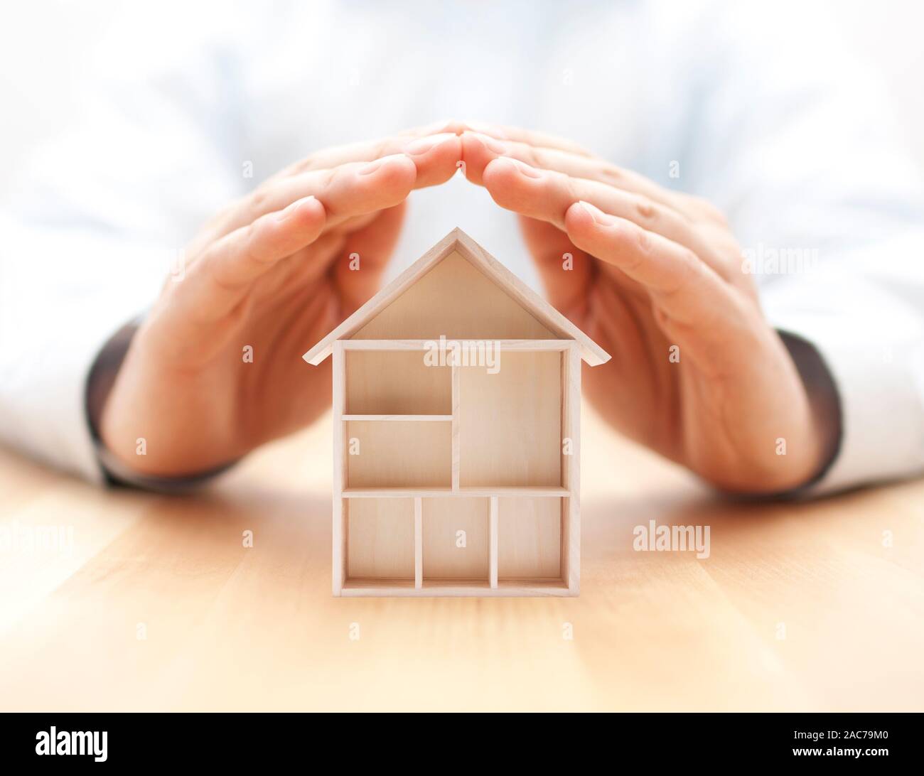 Wooden house protected by hands Stock Photo - Alamy