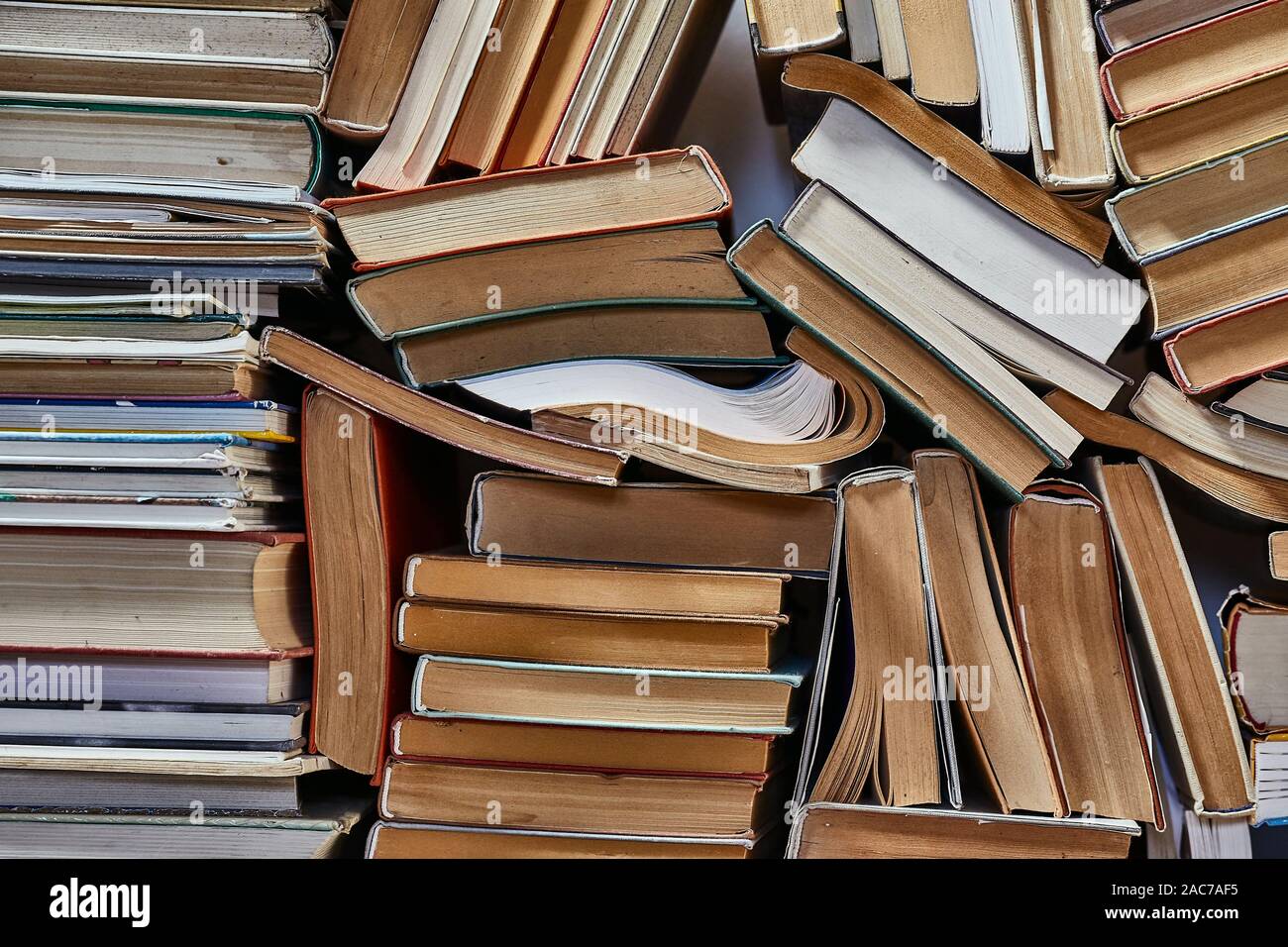 Wall of books piled up Stock Photo - Alamy