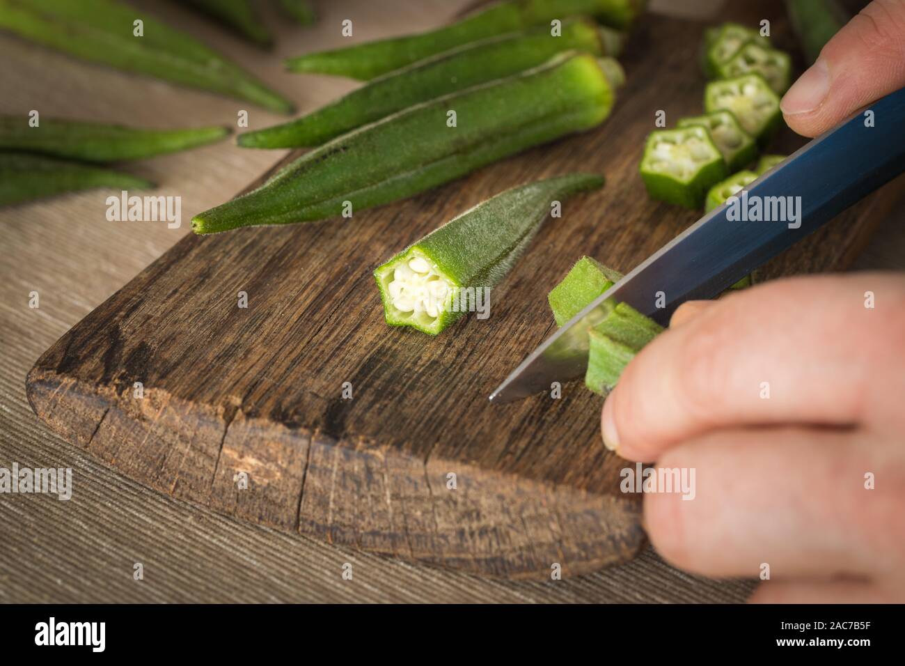 Okra cut with a knife on a chopping board in the kitchen Stock Photo ...
