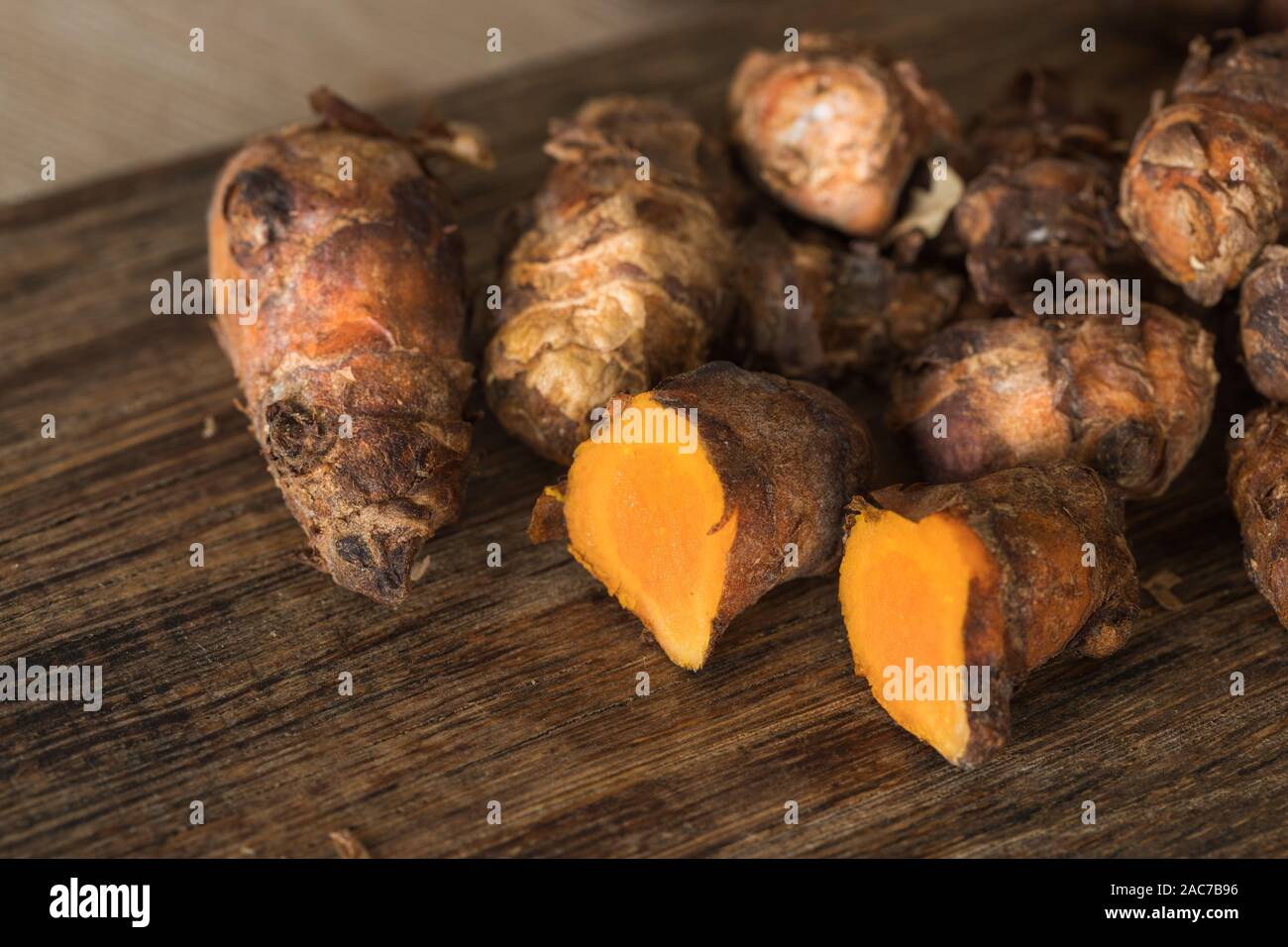 Turmeric on chopping board, whole pieces and cut in half Stock Photo ...