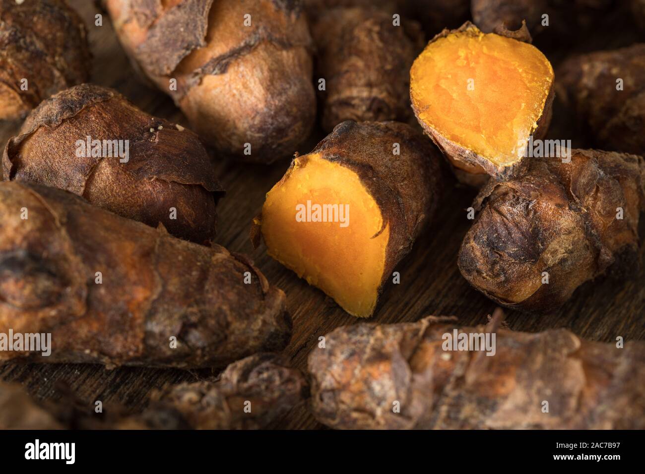Turmeric on chopping board, whole pieces and cut in half Stock Photo ...