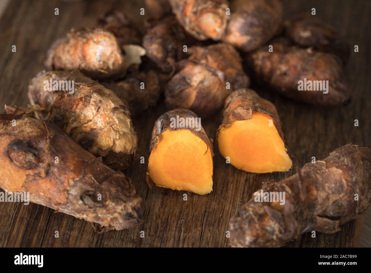 Turmeric on chopping board, whole pieces and cut in half Stock Photo ...