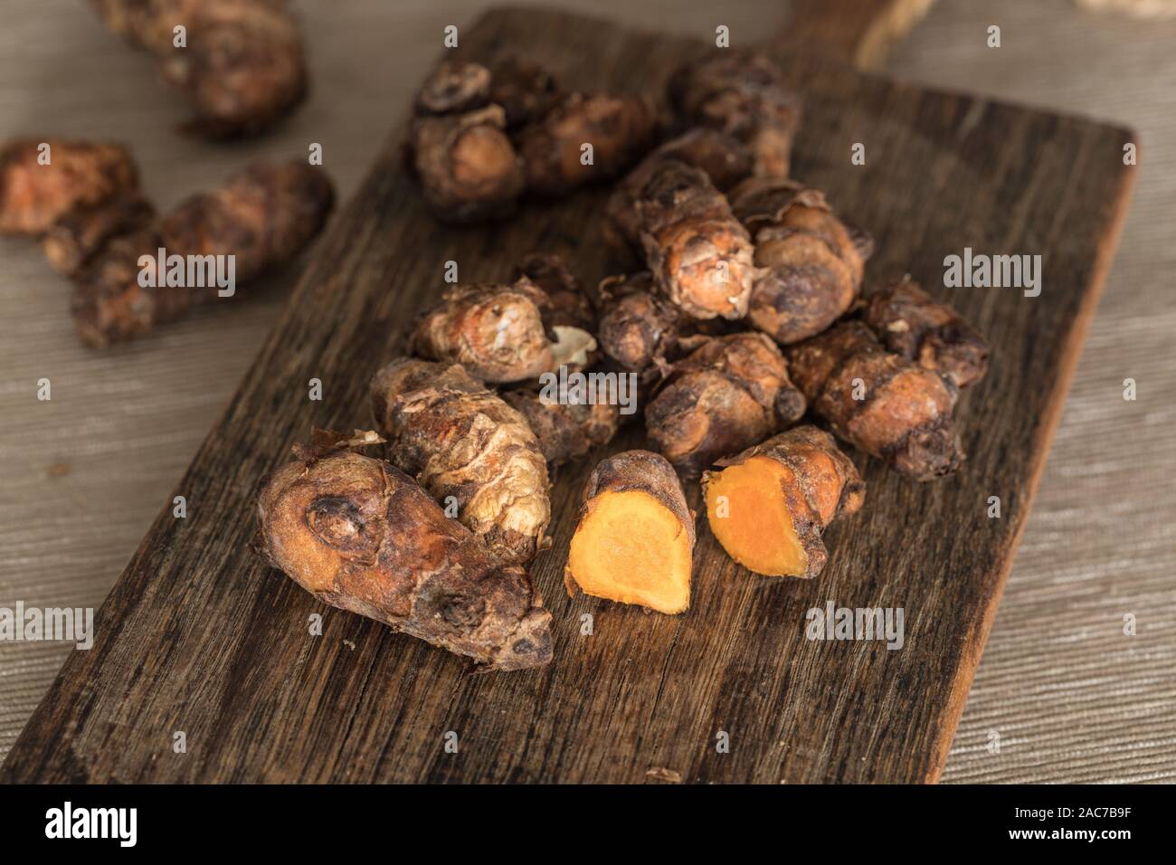 Turmeric on chopping board, whole pieces and cut in half Stock Photo ...