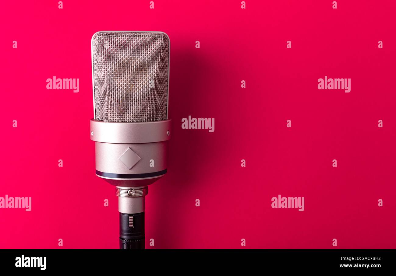 Large diaphragm condenser studio microphone. On red background Stock ...
