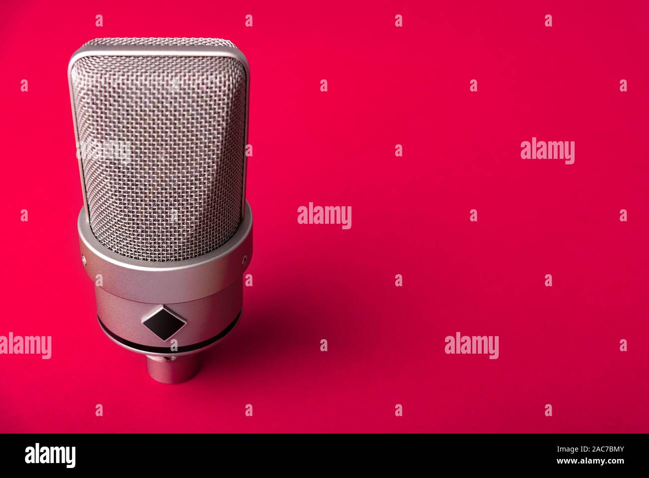 Large diaphragm condenser studio microphone. On a red background Stock ...