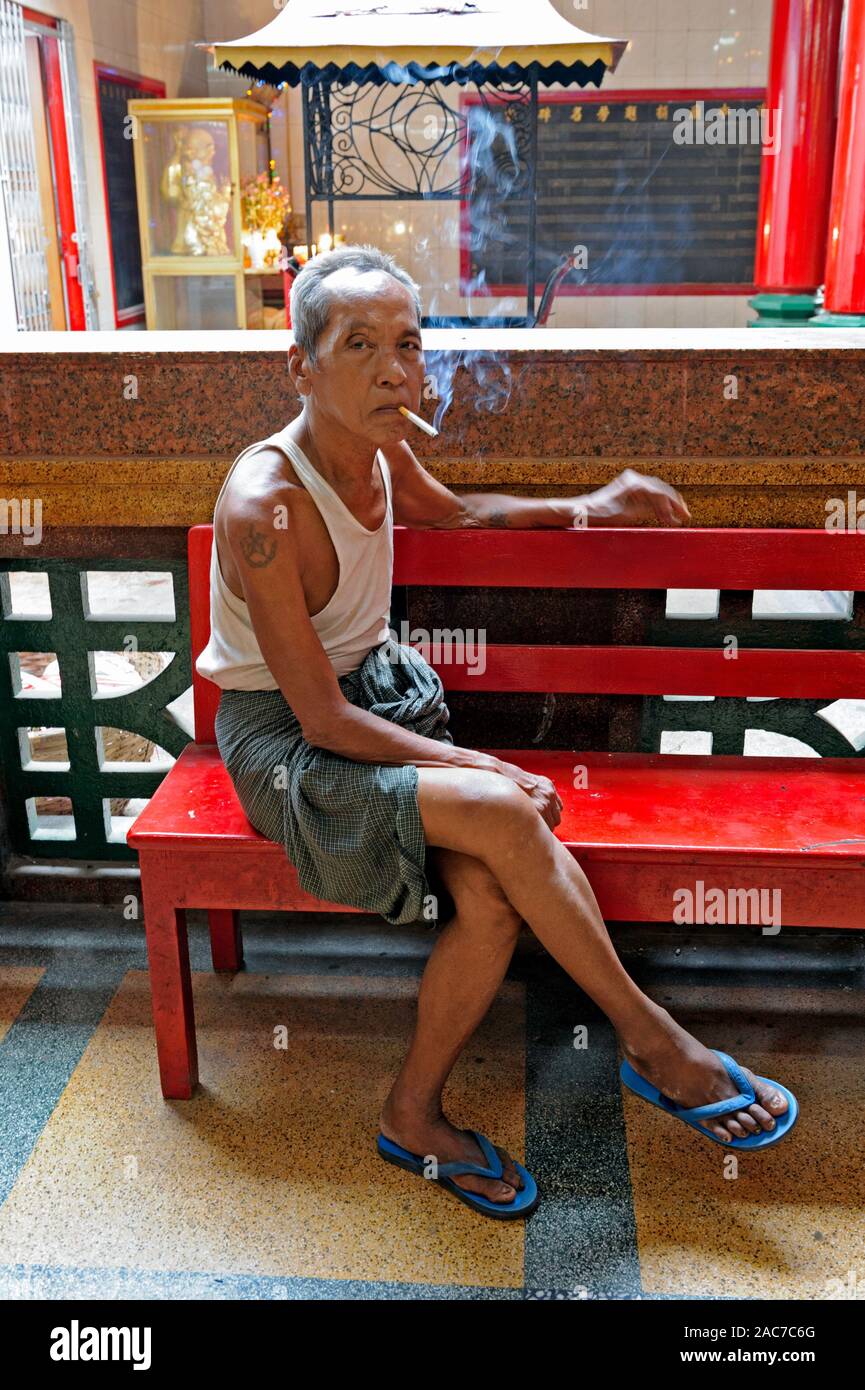 Man smoking a cigarette in the Chinatown area of Yangon, Myanmar Burma ...