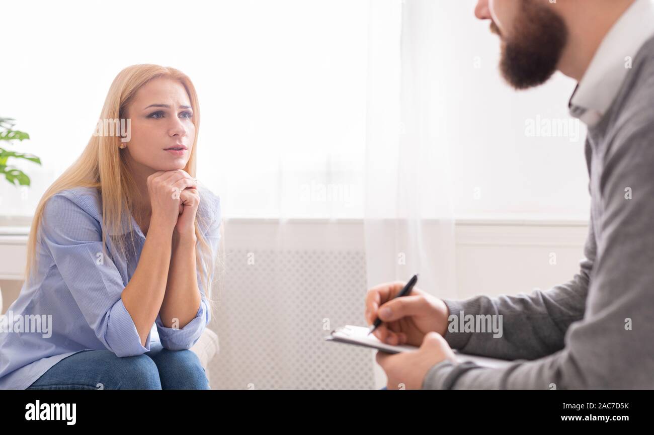 Sad woman talking with male therapist during personal session Stock ...