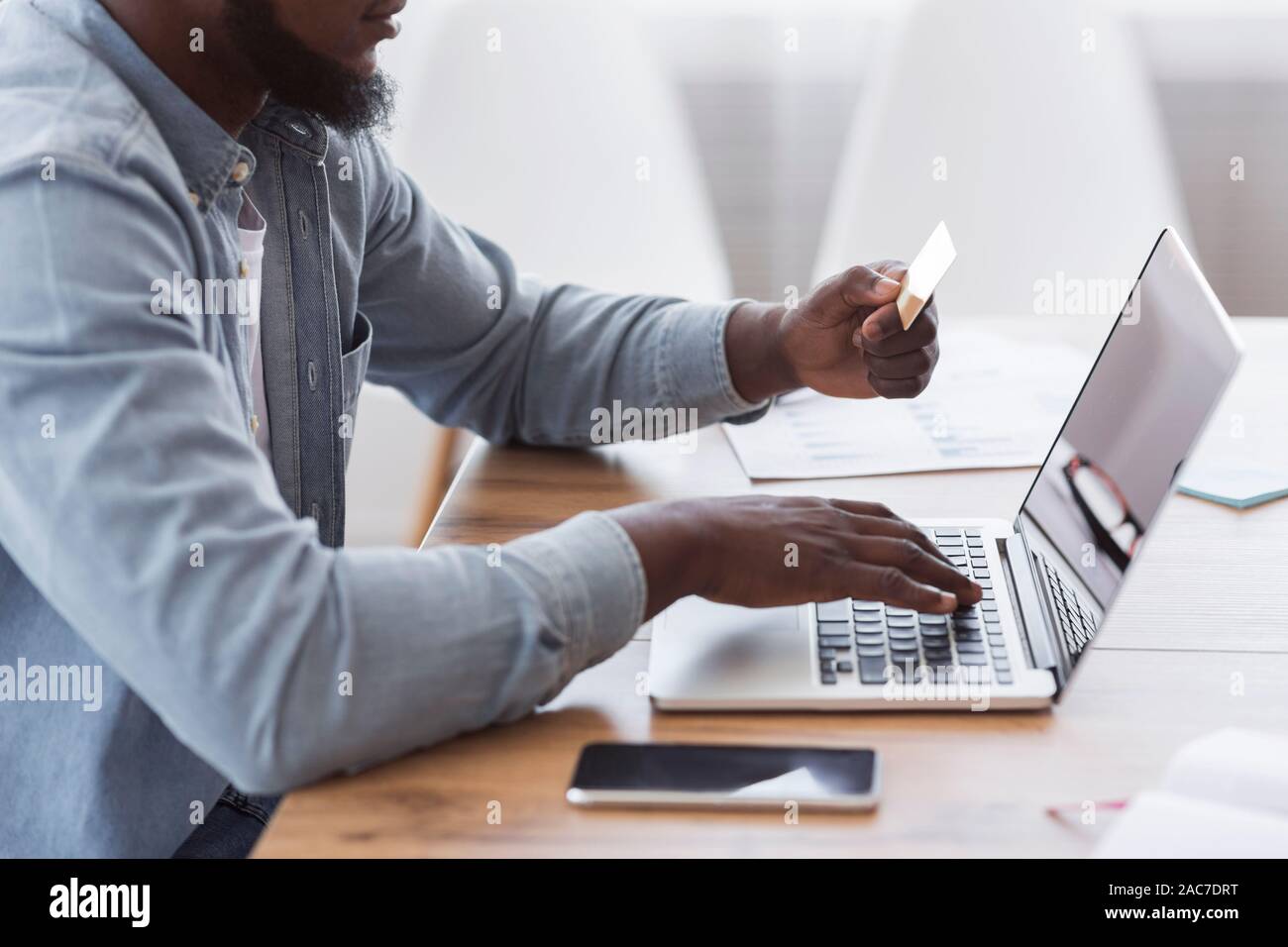 Black businessman paying his bills online with laptop and credit card ...