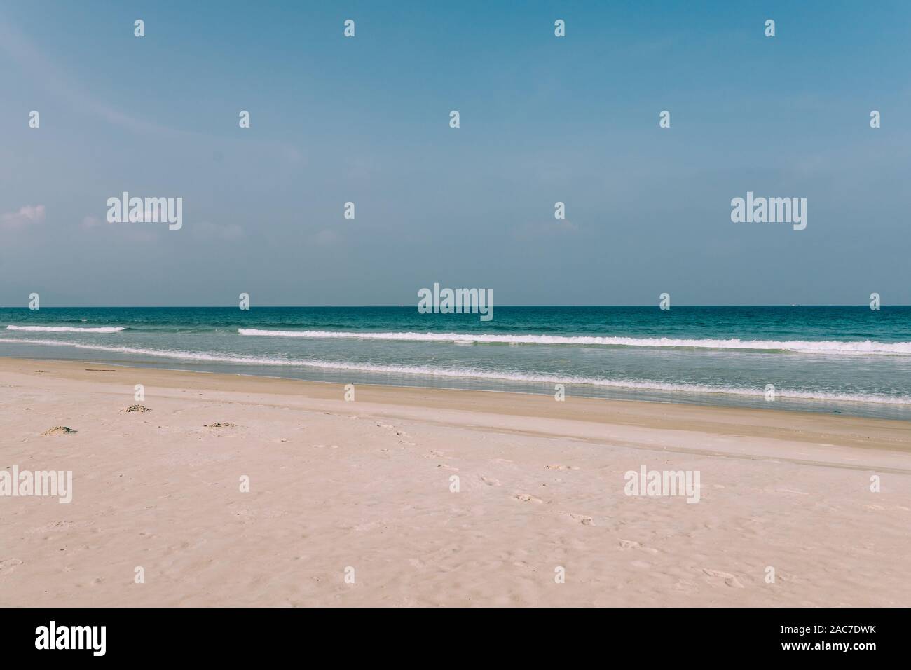 Beautiful, empty tropical white sand beach, small waves in the sea ...