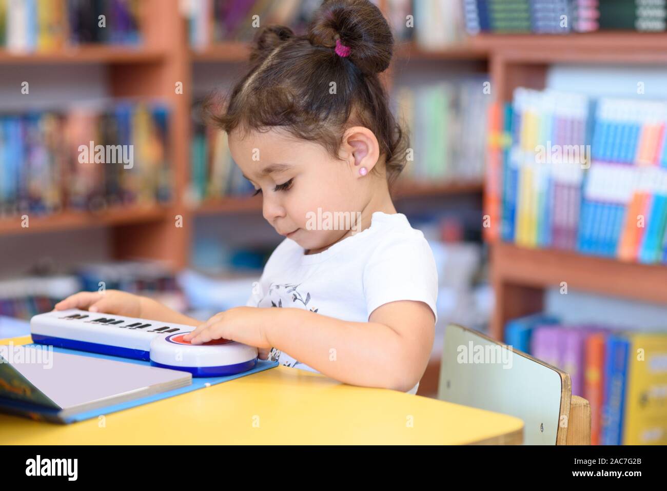 Little Girl Reading in the Library Stock Photo - Alamy