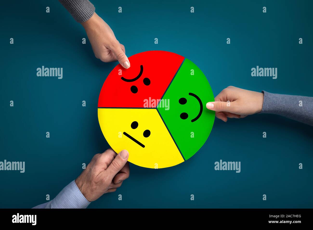 Customer hands giving feedback with smiley faces cards on blue Stock ...