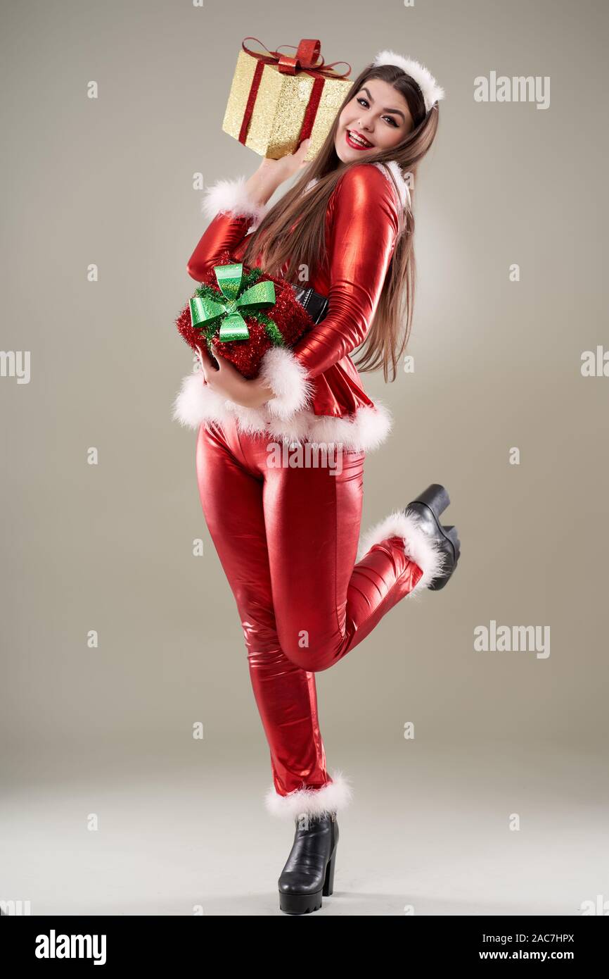 Full length of a Santa girl bearing presents Stock Photo - Alamy