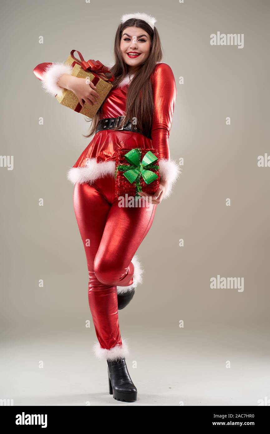 Full length of a Santa girl bearing presents Stock Photo - Alamy