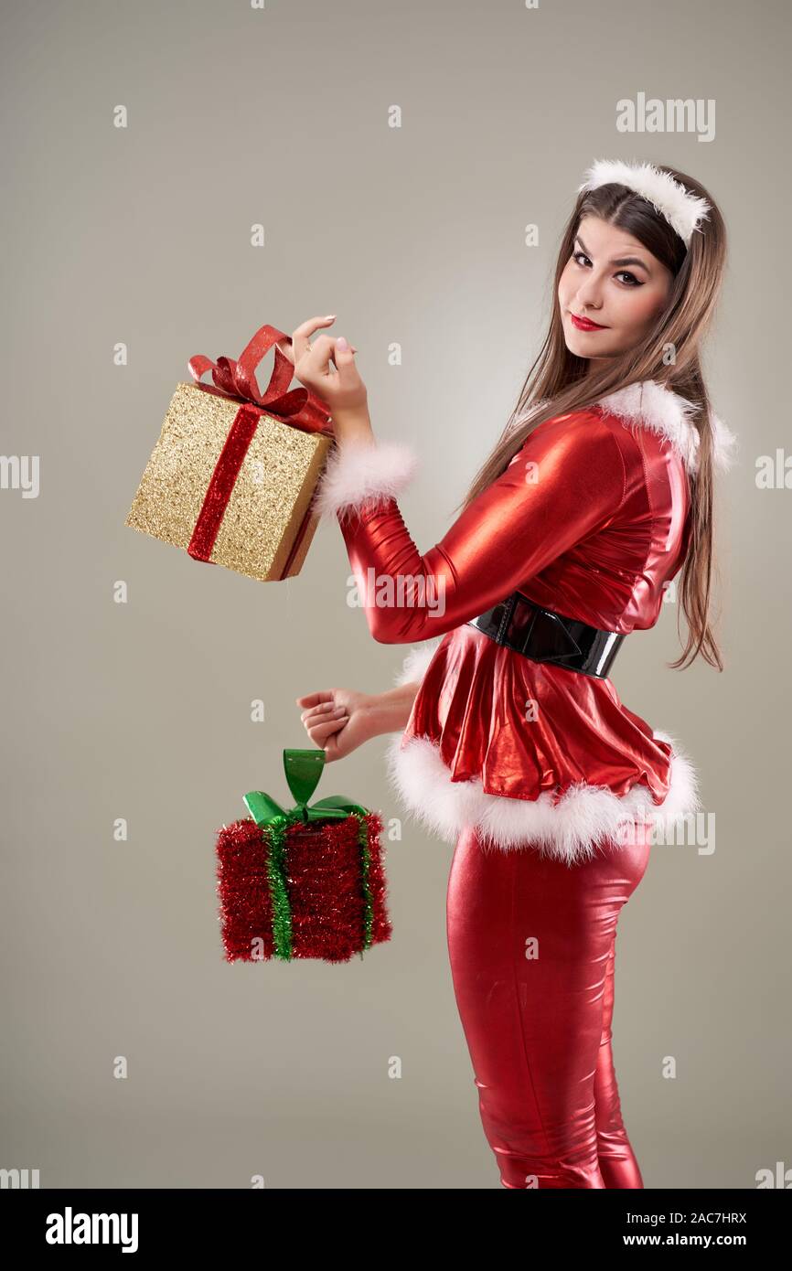 Beautiful young Santa girl with presents to give Stock Photo - Alamy