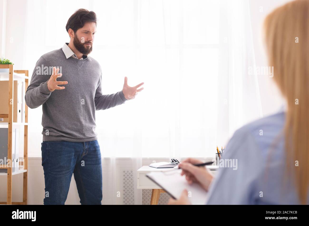 Puzzled man talking about life problems with psychologist Stock Photo ...