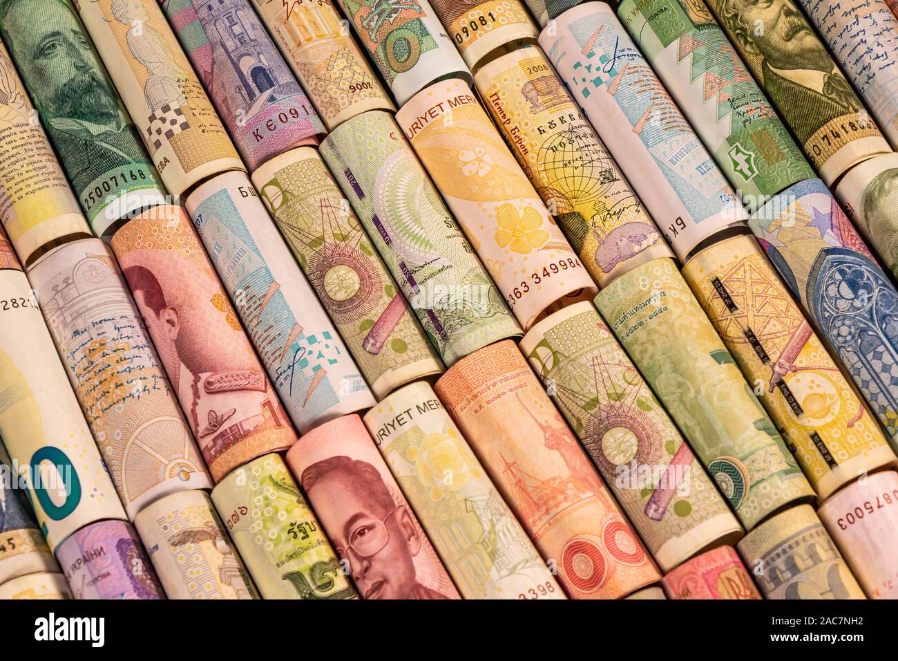 Different colourful banknotes from various countries on rolls to be ...