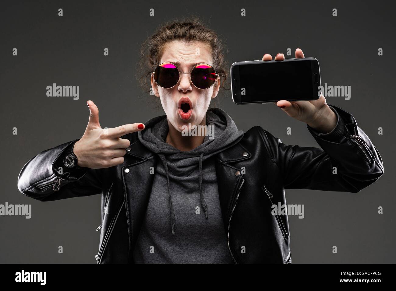 Stubborn caucasian girl with rough facial features in a black jacket ...