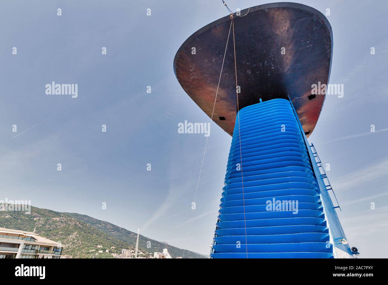 Cruise ship pipe closeup against Bastia cityscape and clear blue sky ...
