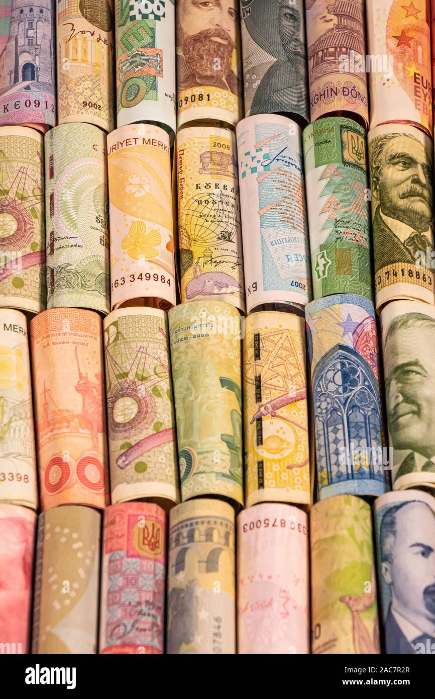 Different colourful banknotes from various countries on rolls to be ...