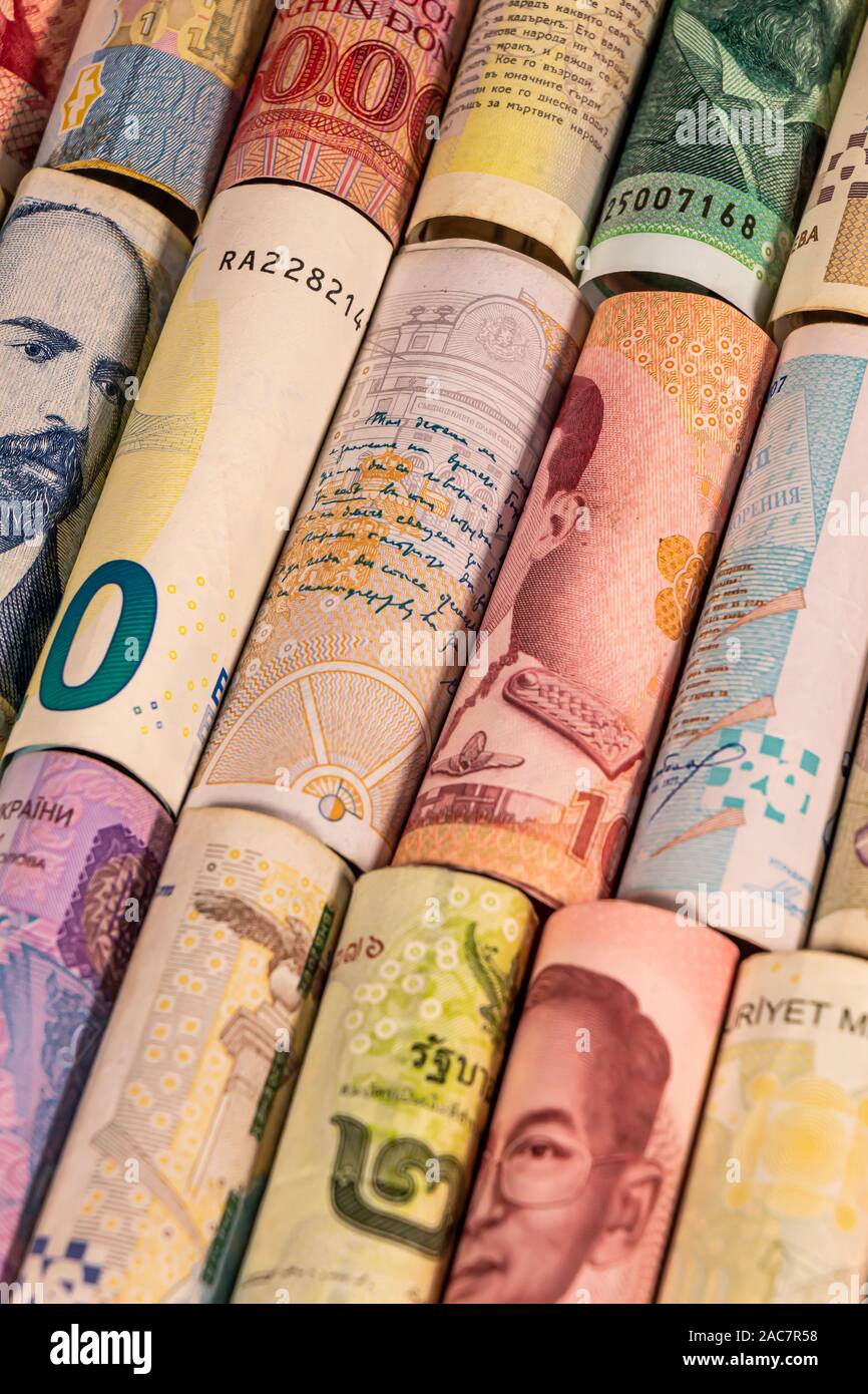 Different colourful banknotes from various countries on rolls to be ...