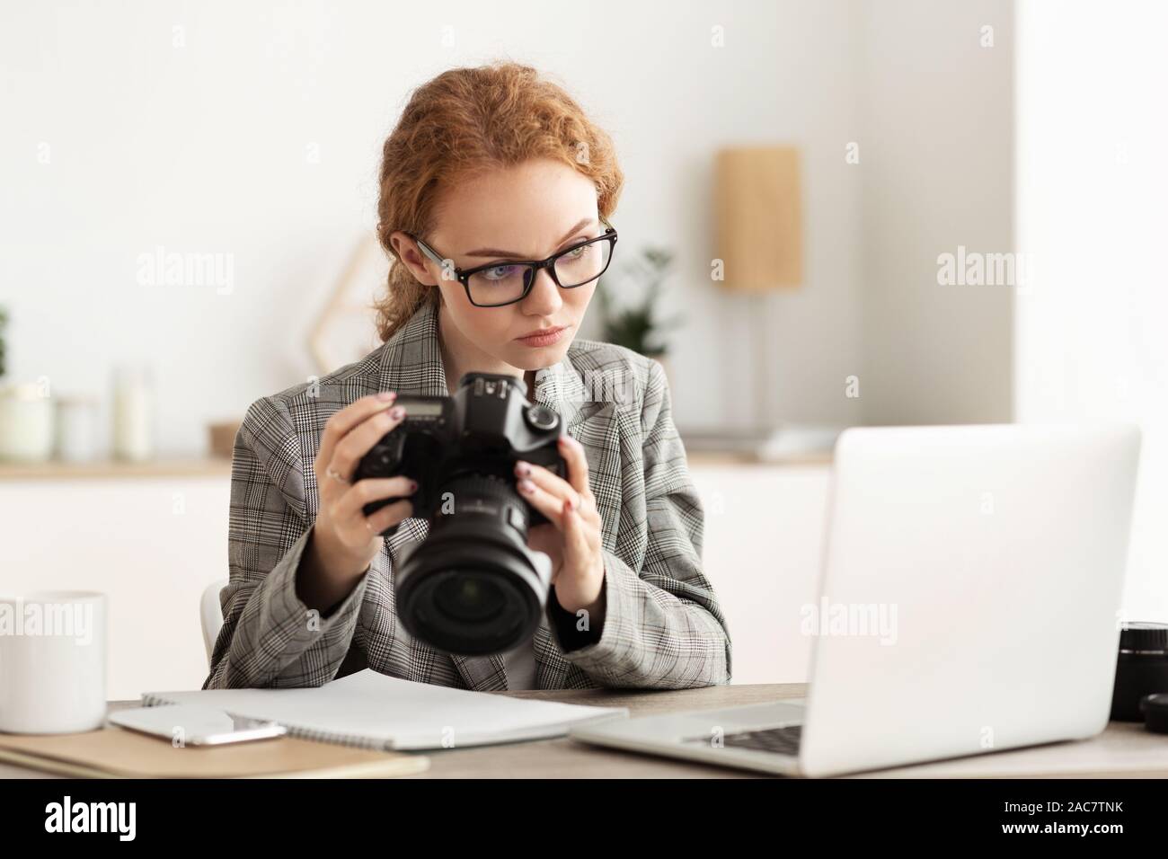 Reporter off loading files from camera to laptop Stock Photo - Alamy