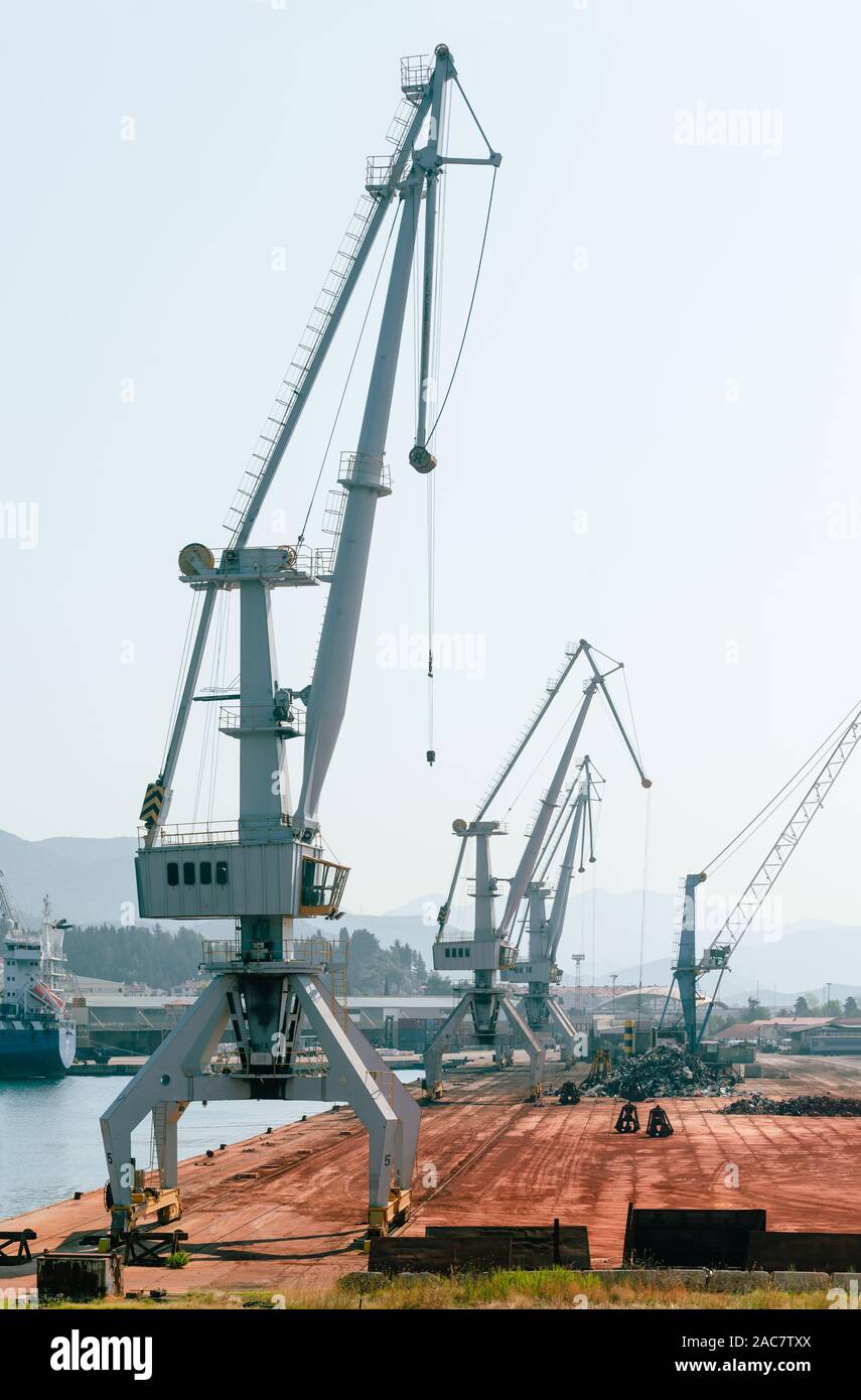 Loading crane with excavator shovel in a pile of iron ore at a loading ...