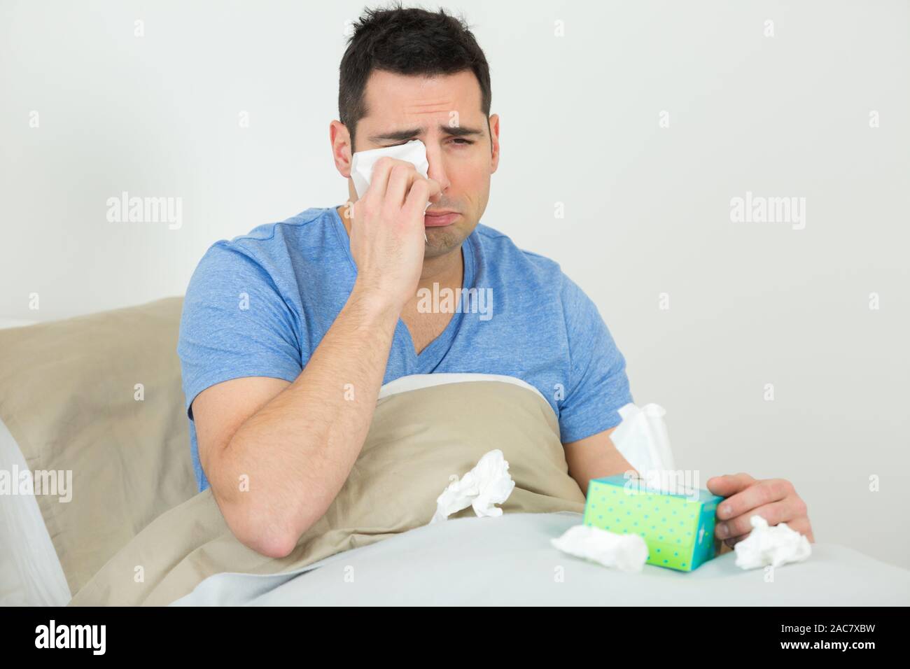 sad young man holding a box of paper tissues Stock Photo - Alamy