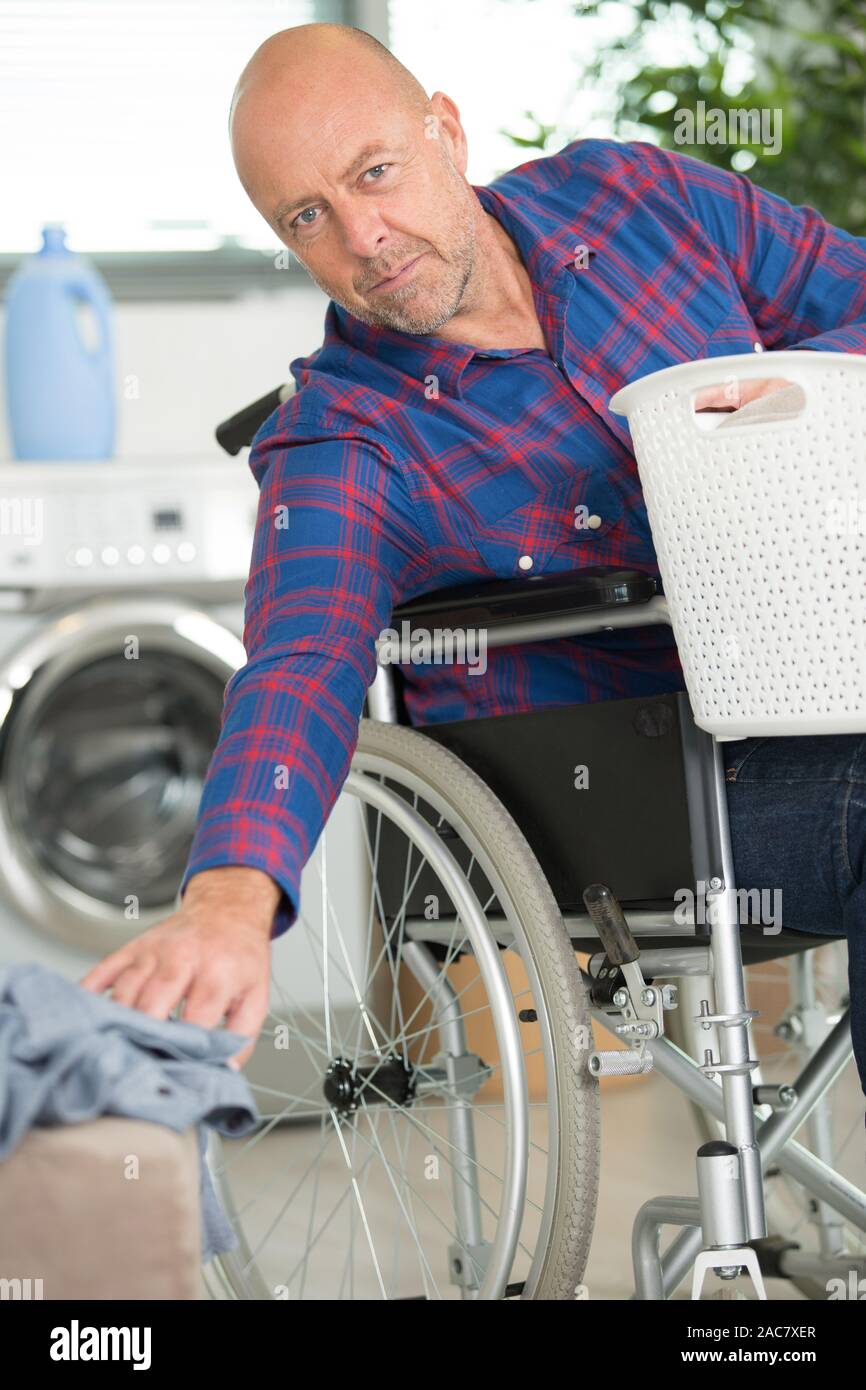 happy disabled man on wheelchair doing laundry Stock Photo - Alamy