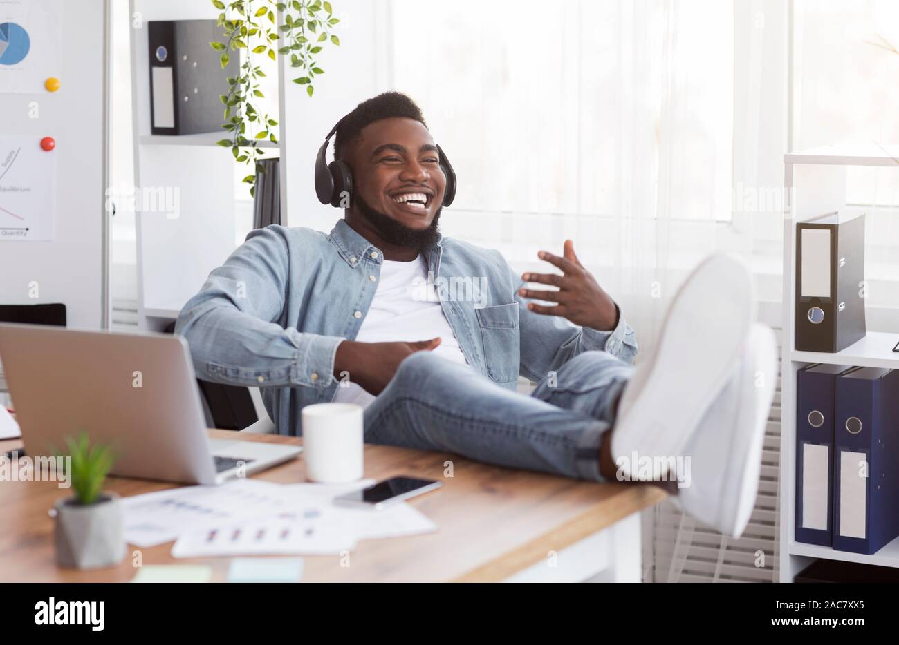 Young man playing guitar at office hi-res stock photography and images ...