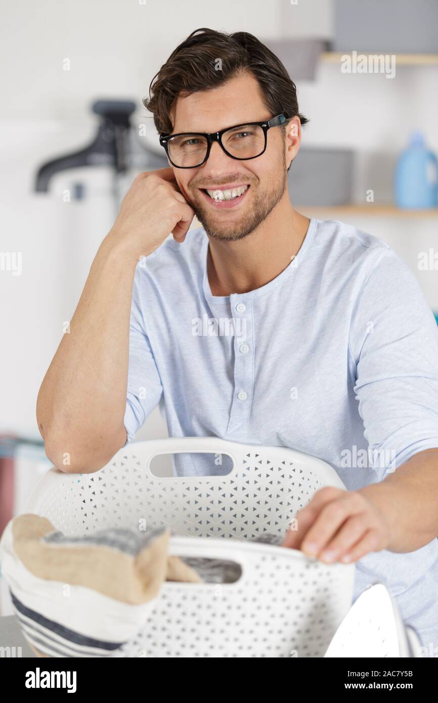 happy man taking clothes from drying rack Stock Photo - Alamy