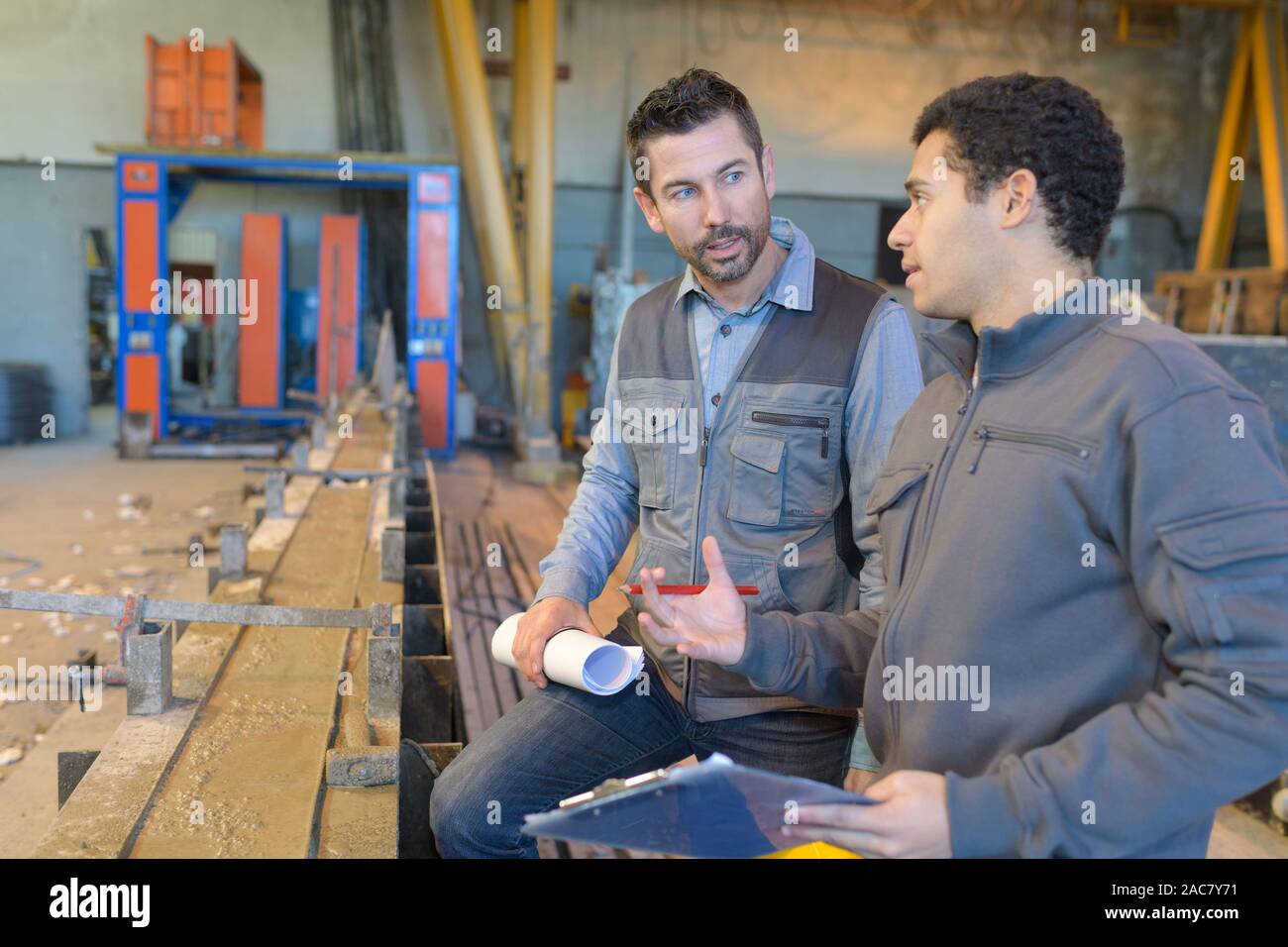 factory workers discussing something Stock Photo - Alamy